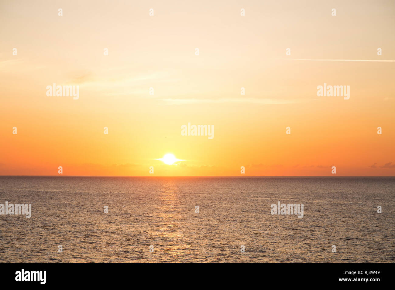 Sun rising over sea Stock Photo - Alamy