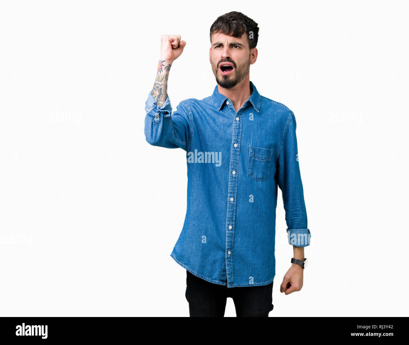 Young handsome man over isolated background angry and mad raising fist ...