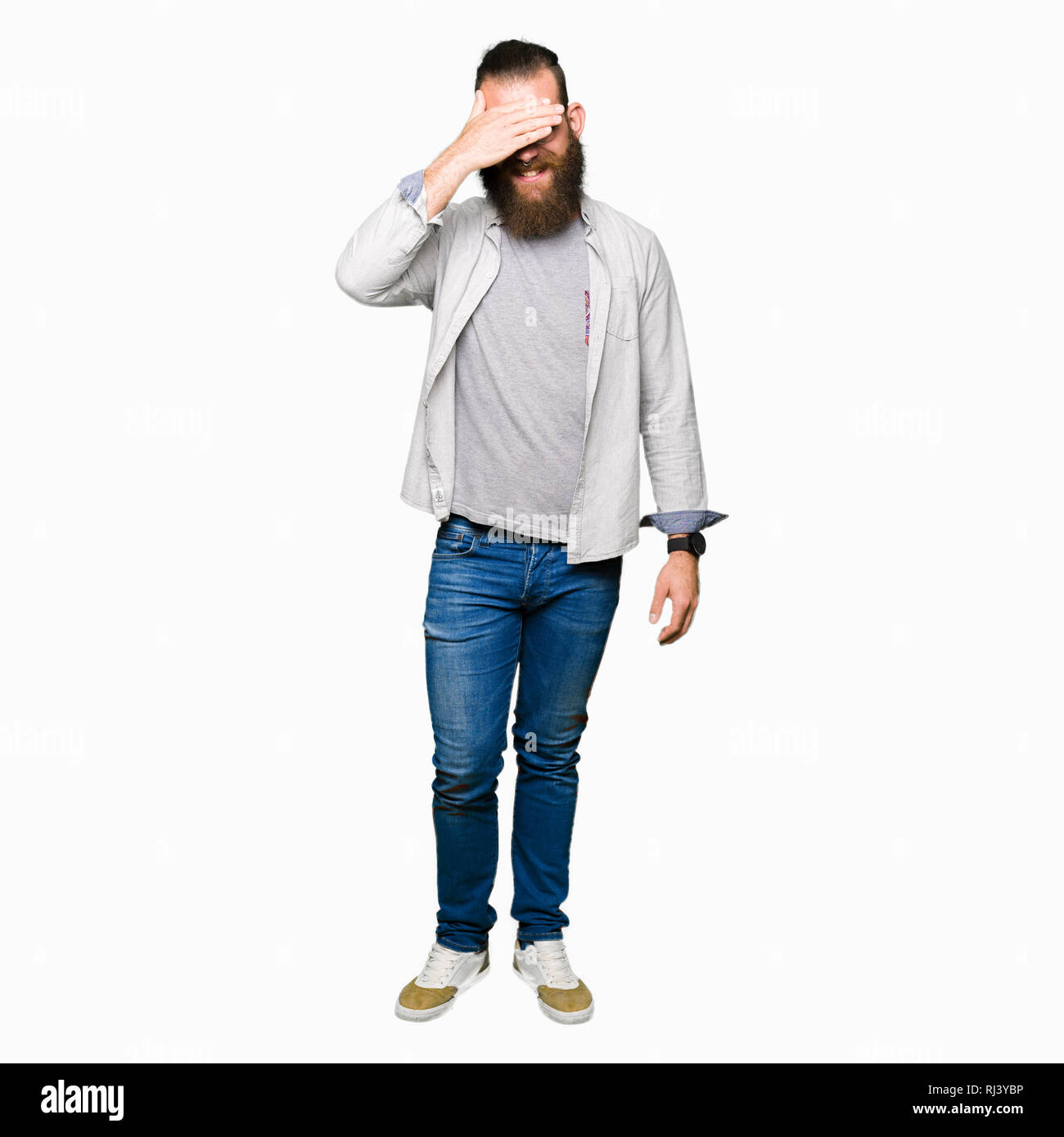 Young blond man wearing glasses smiling and laughing with hand on face ...