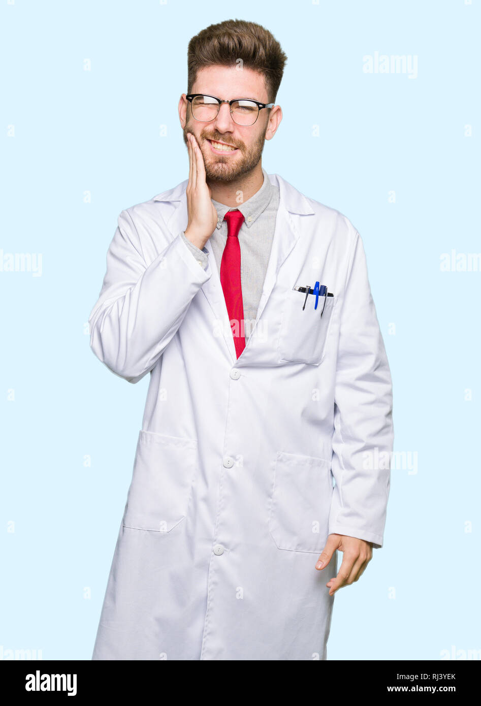 Young handsome scientist man wearing glasses touching mouth with hand ...