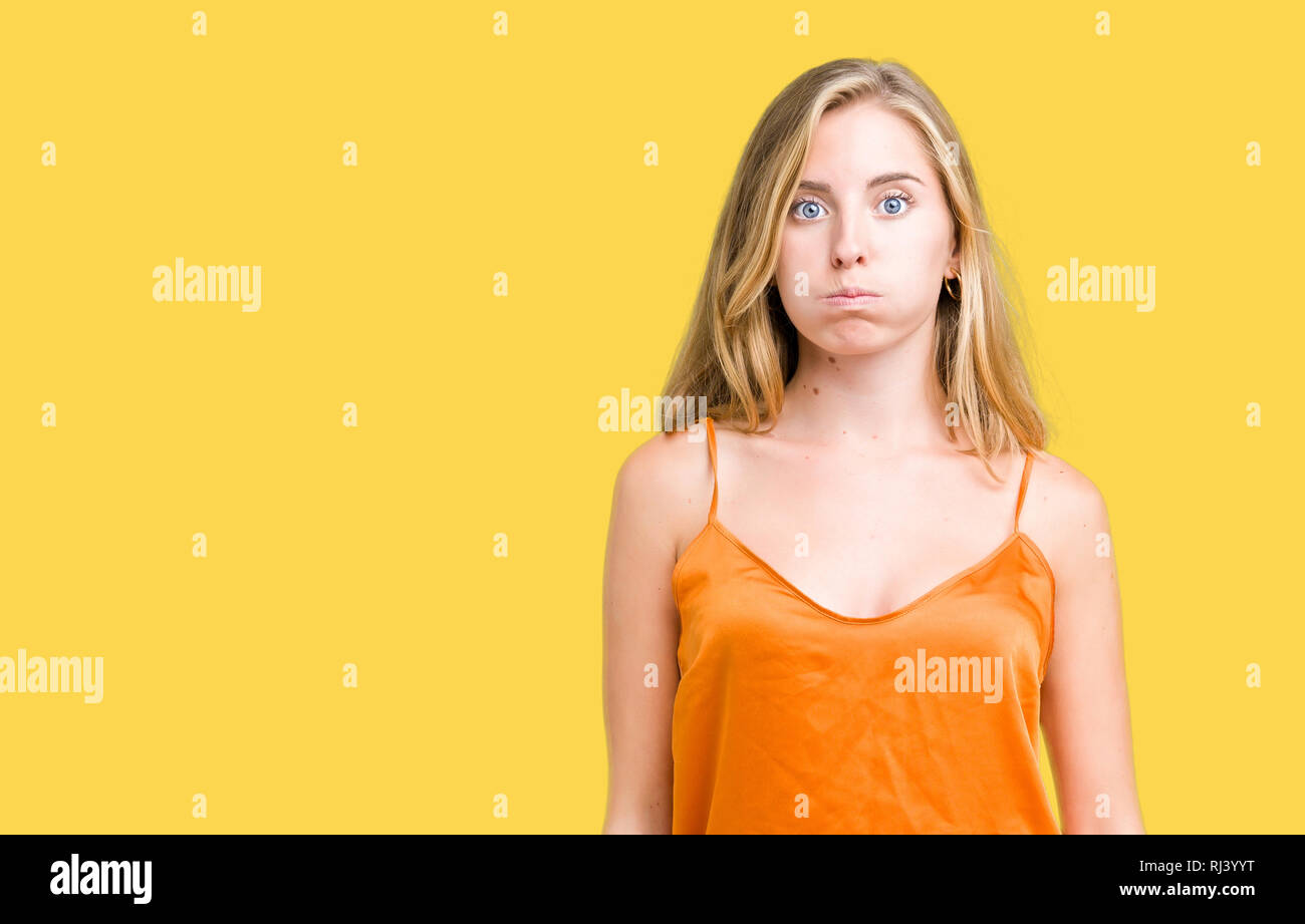 Beautiful young woman wearing orange shirt over isolated background ...