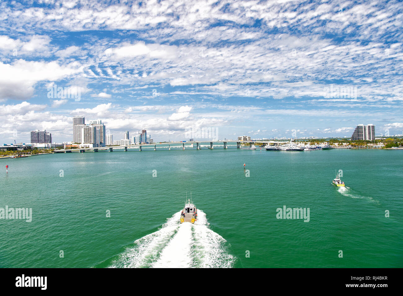 Aerial view of Miami skyscrapers with blue cloudy sky,white boat ...