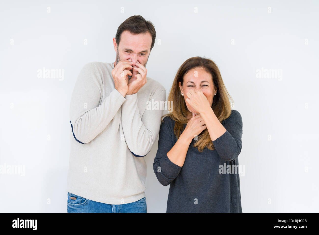 Beautiful middle age couple in love over isolated background smelling ...