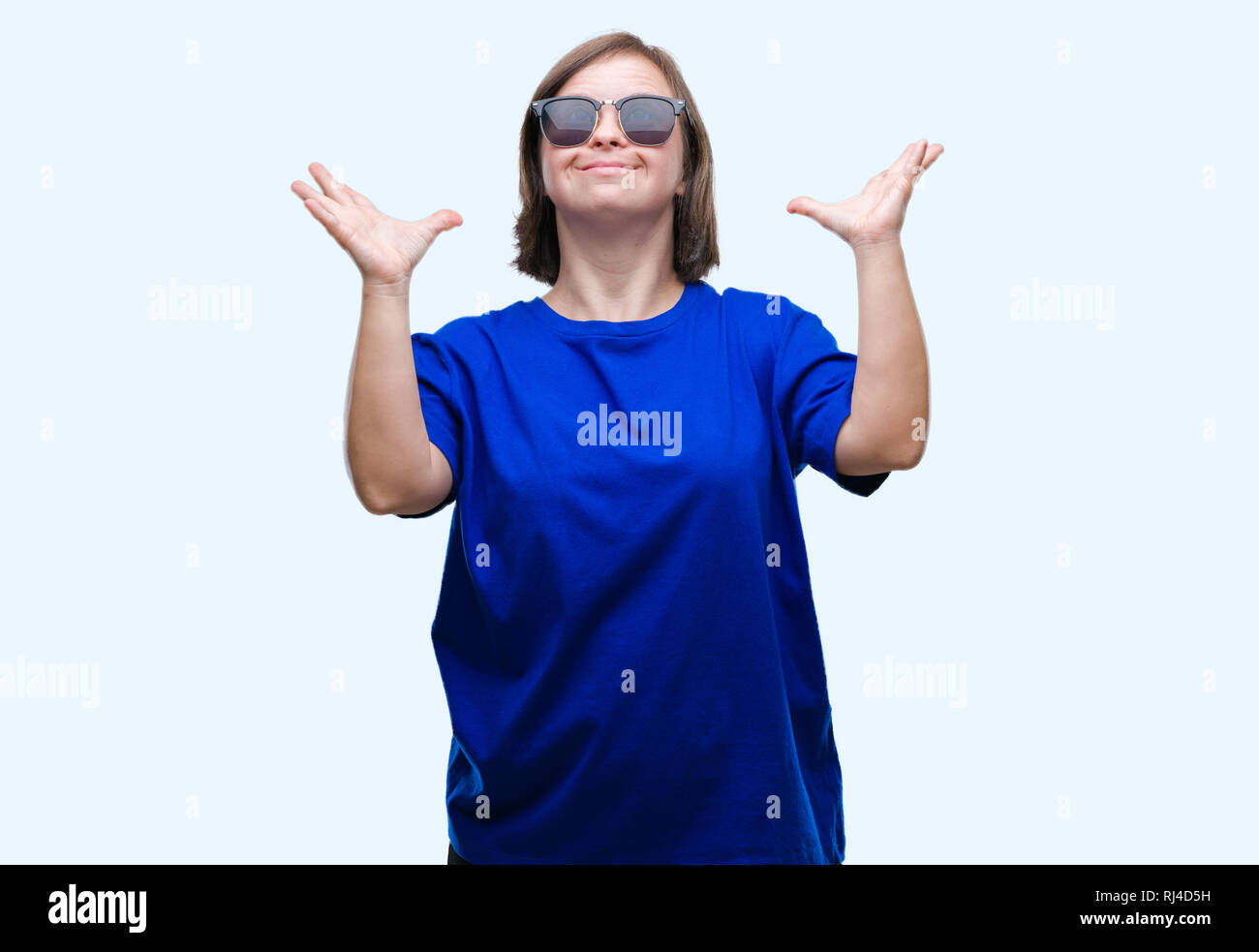 Young adult woman with down syndrome wearing sunglasses over isolated ...