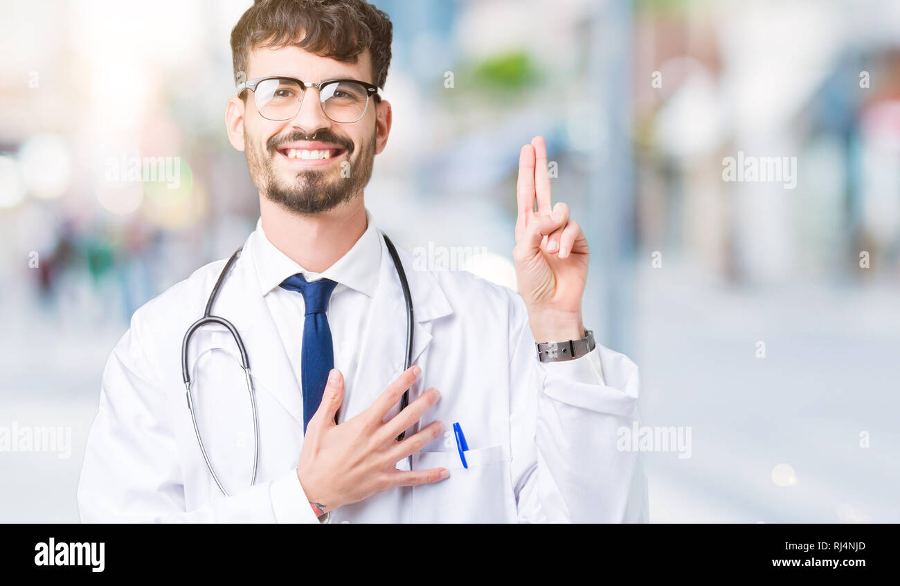 Young doctor man wearing hospital coat over isolated background ...