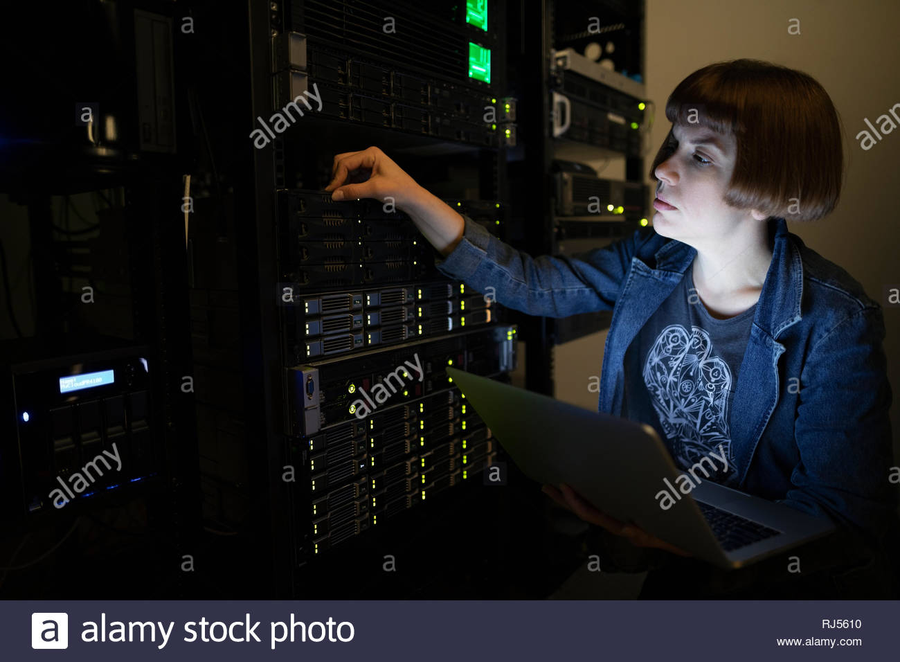 Female IT technician with laptop in server room Stock Photo - Alamy