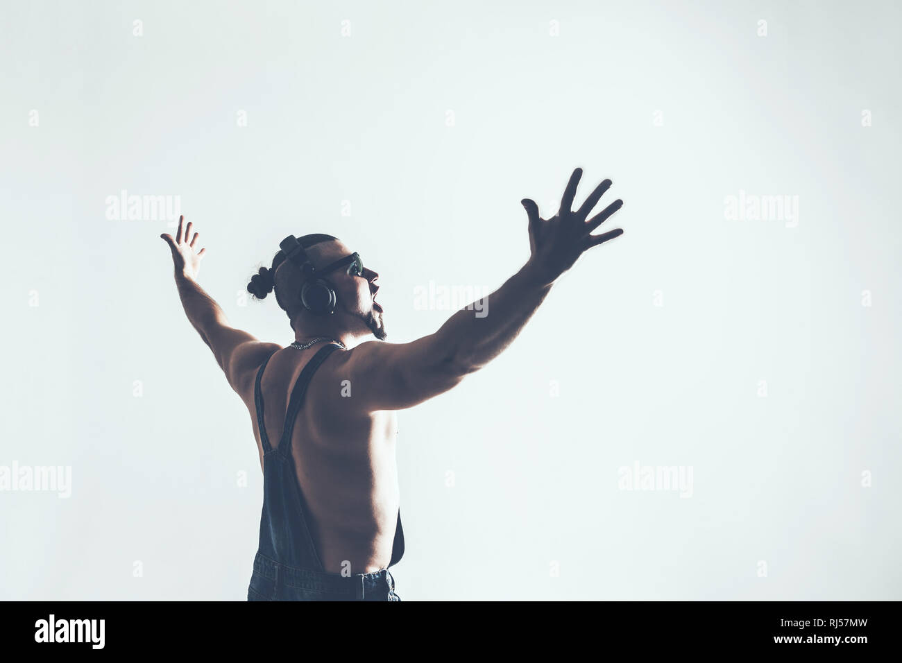 side view - DJ - rapper with headphones on a light background pe Stock ...