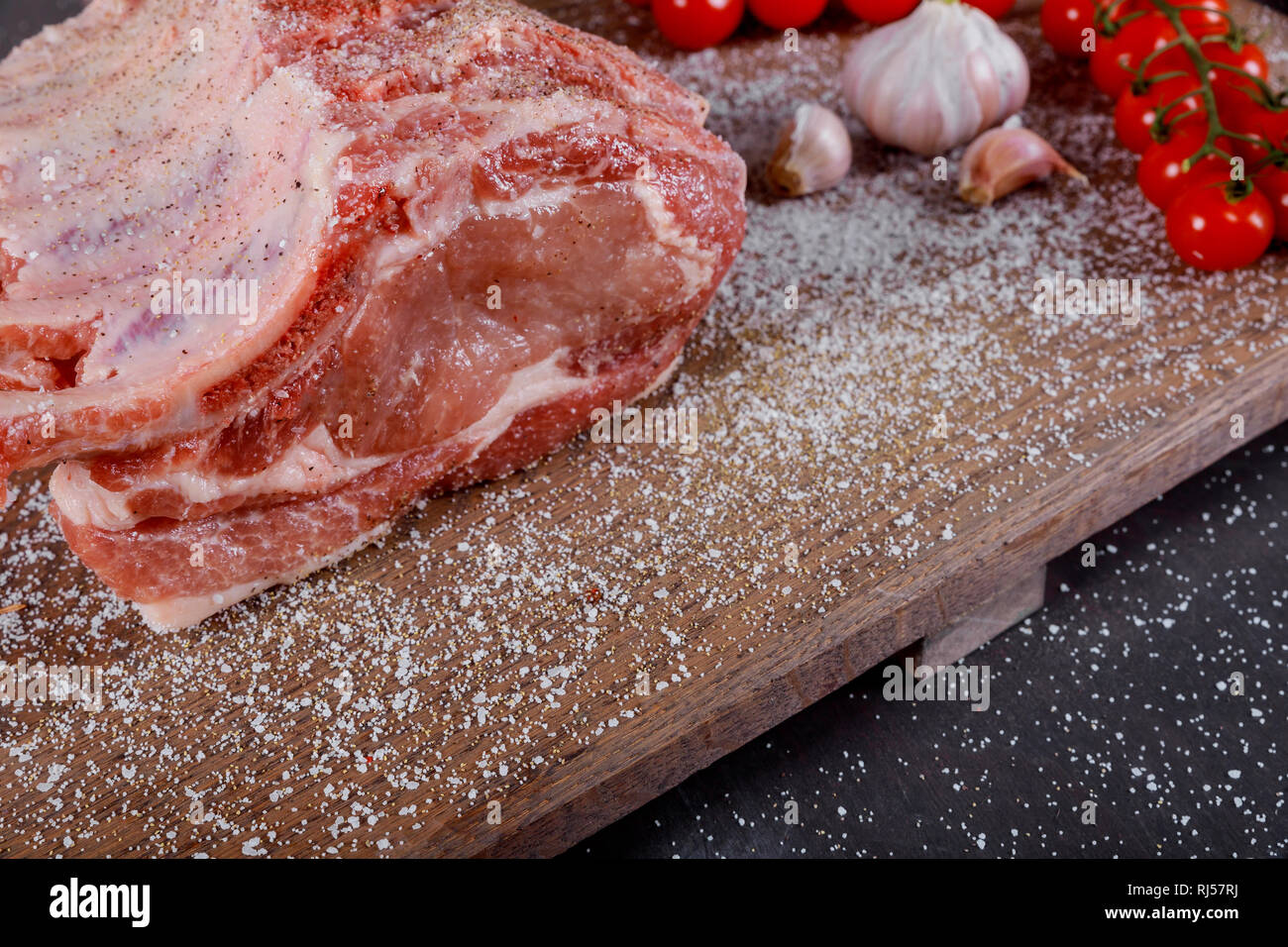Marinated ready to cook pork steak and ingredients on a wood board ...