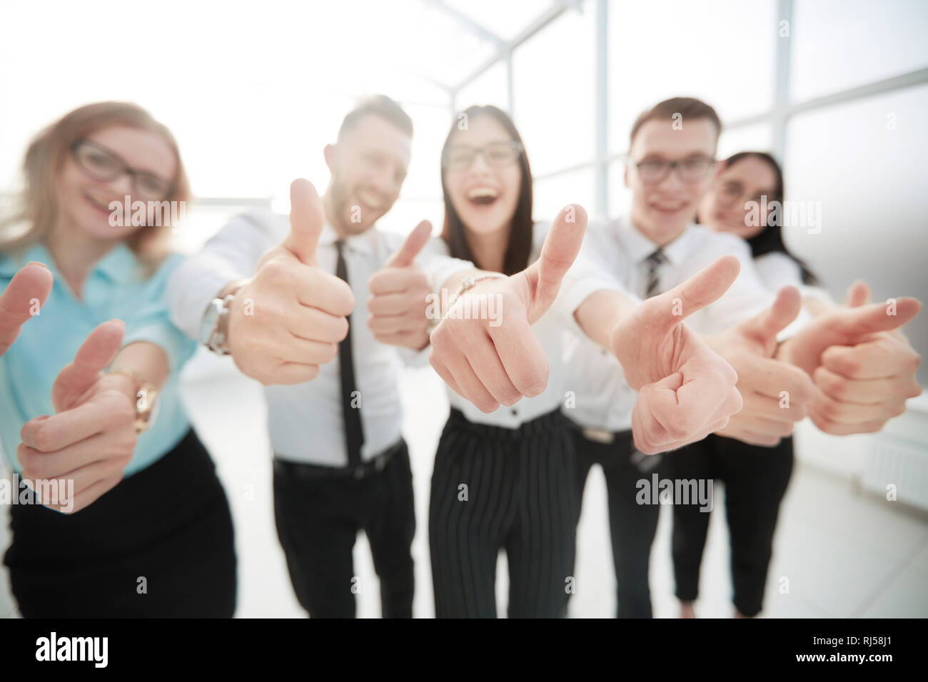 fun business team showing their thumbs up Stock Photo - Alamy