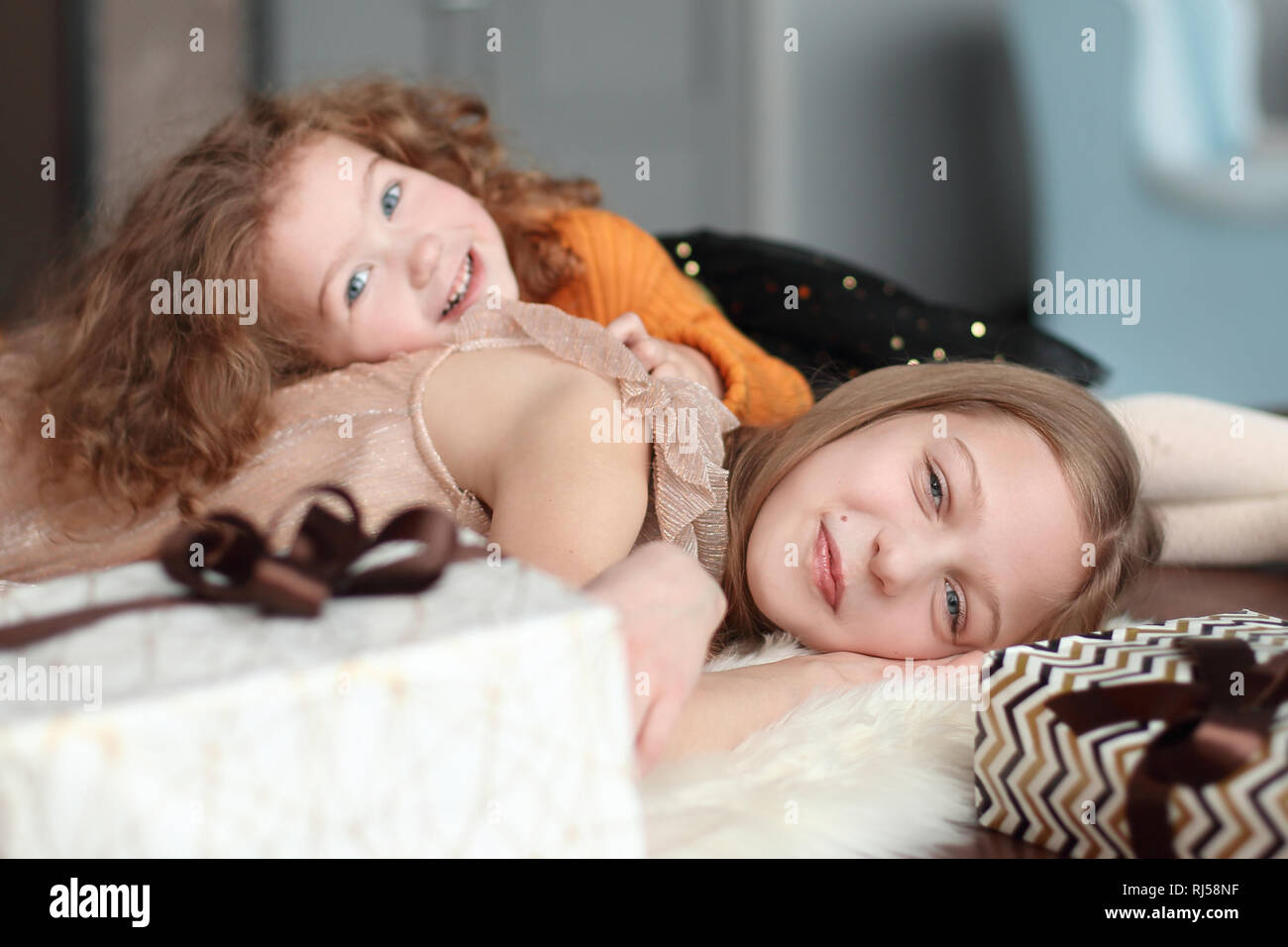 two pretty sisters lying on the floor in a cozy living room Stock Photo ...