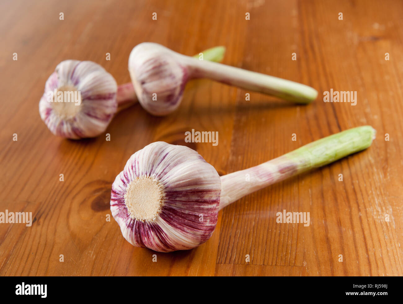 Fresh cut garlic bulbs vegetable lying on wooden table, three bulbs ...