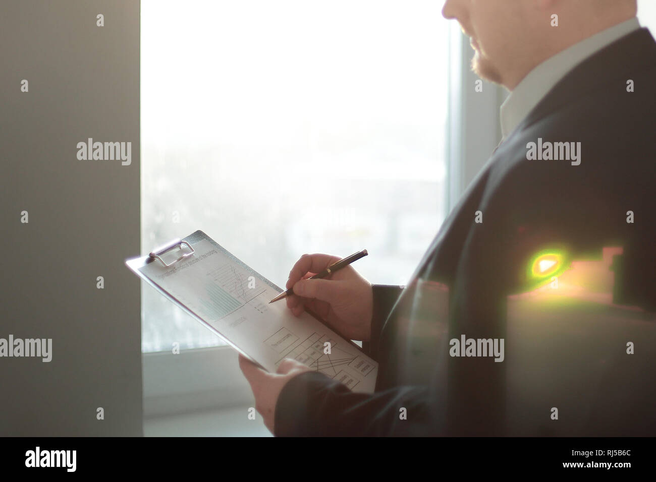 adult businessman signing document standing near office window Stock ...