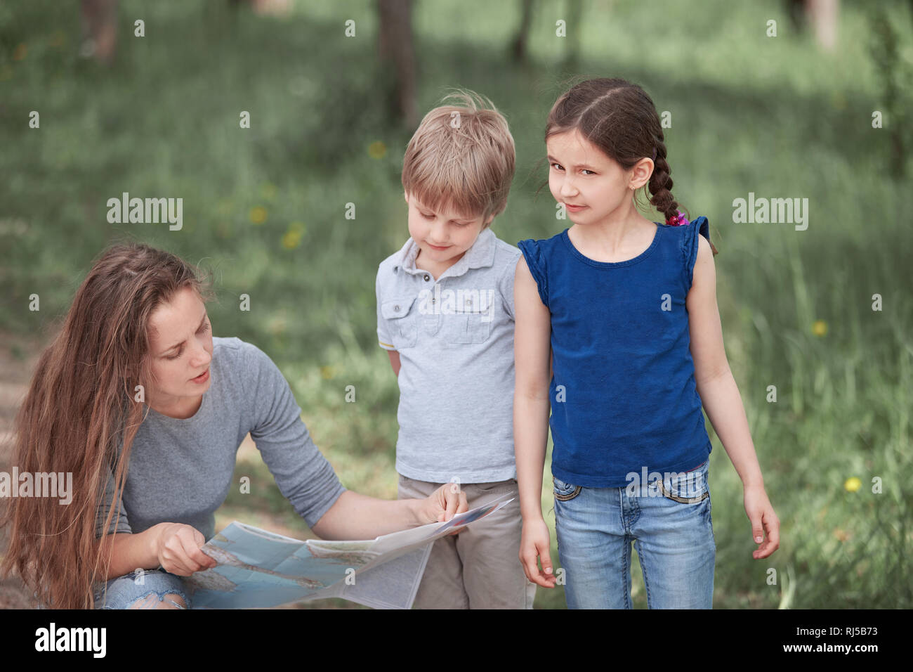 mom with two kids looking at a paper map Stock Photo - Alamy