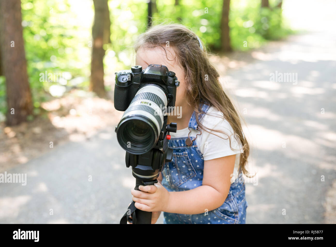 Hobby, children and photographer concept - child with camera in forest ...