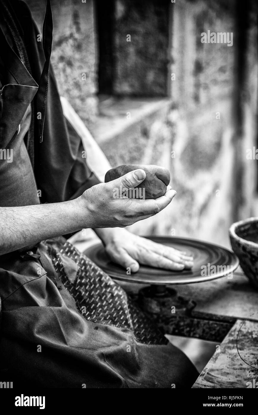 Hands of man working and shaping clay, potter in pottery, craft detail ...