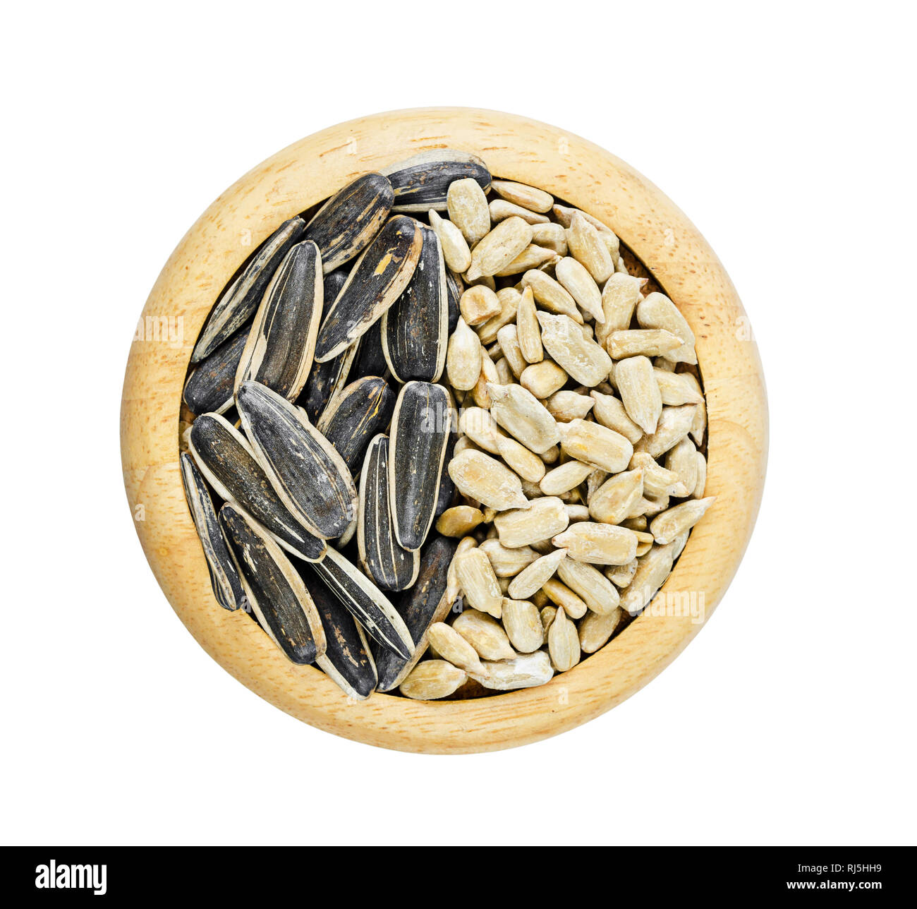 Sunflower seeds and shell in wooden dish isolated on white background ...