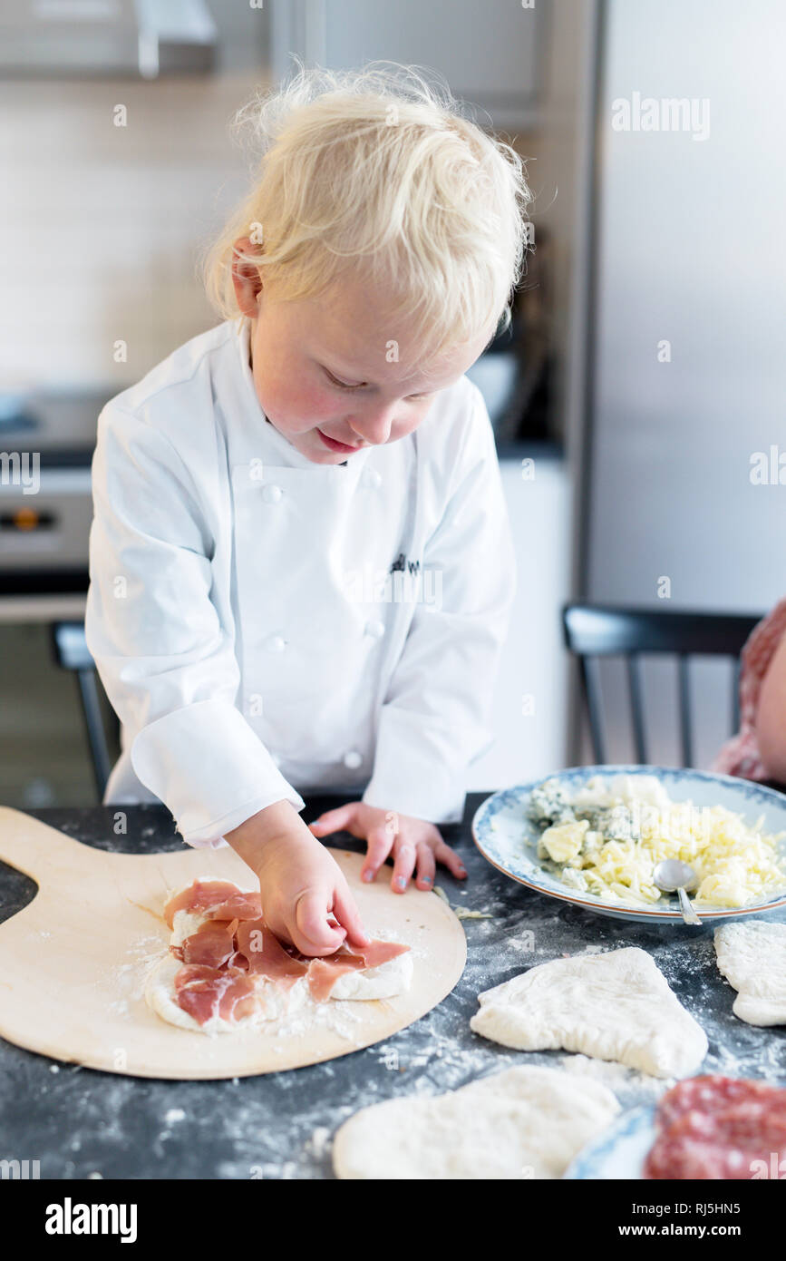 Boy making pizza in kitchen Stock Photo - Alamy