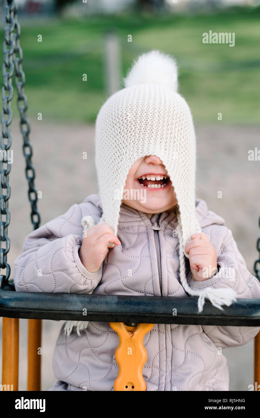 Girl having fun on swing in playground Stock Photo - Alamy