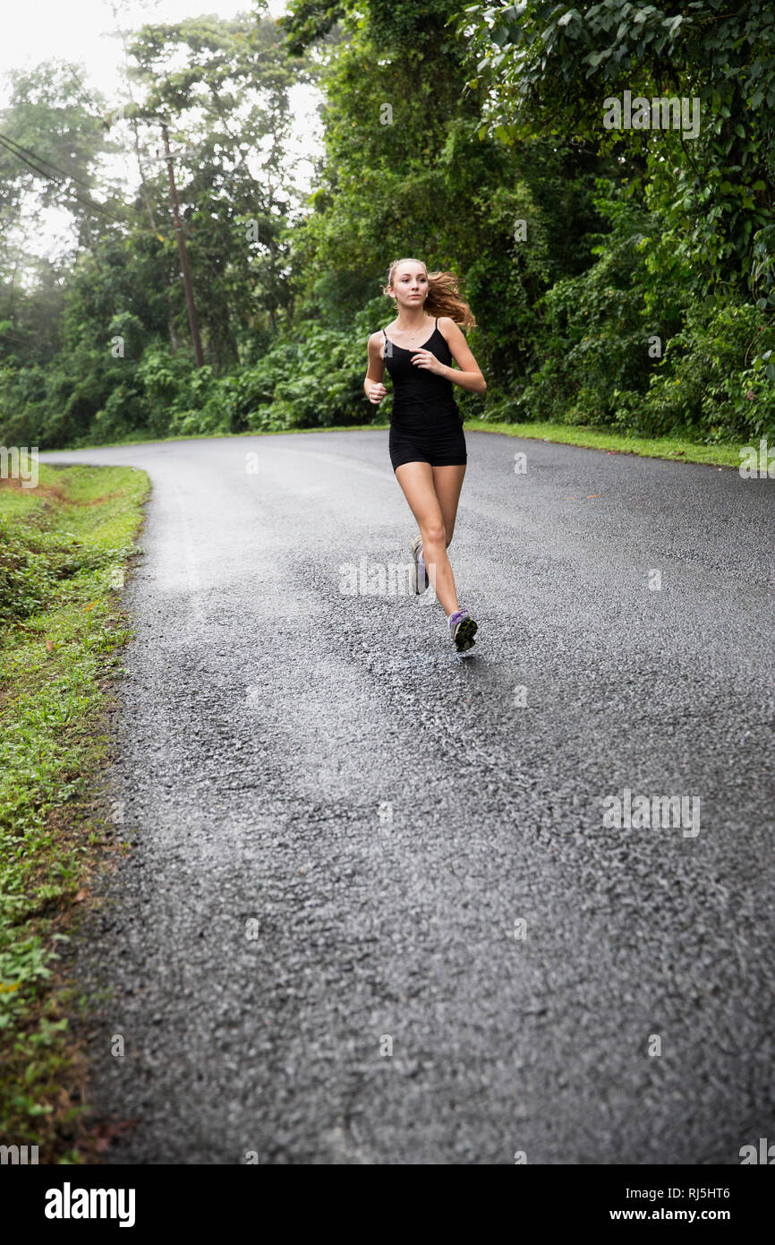 Teenage girl running on country road Stock Photo - Alamy