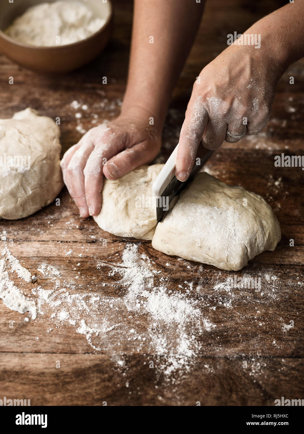 Baker cutting dough Stock Photo - Alamy