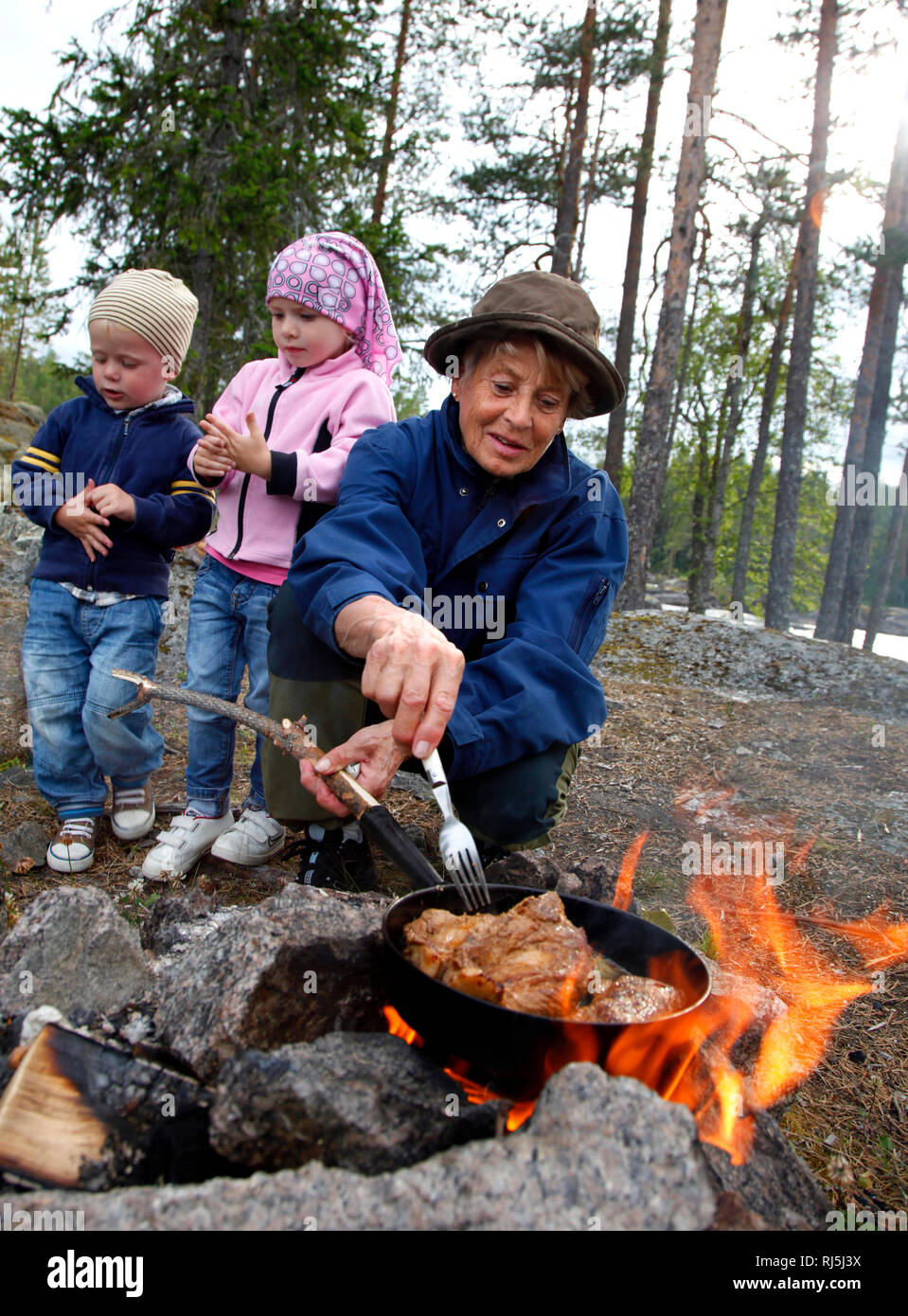 Family cooking over fire Stock Photo - Alamy