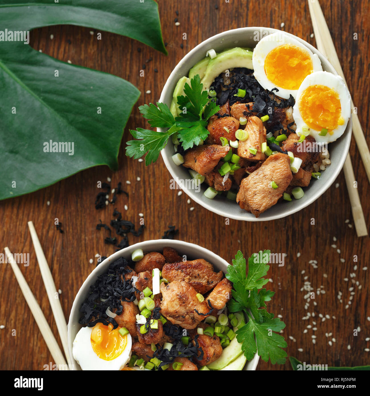 Asian food concept. Poke bowl of fried rice, chicken fillet and eggs ...