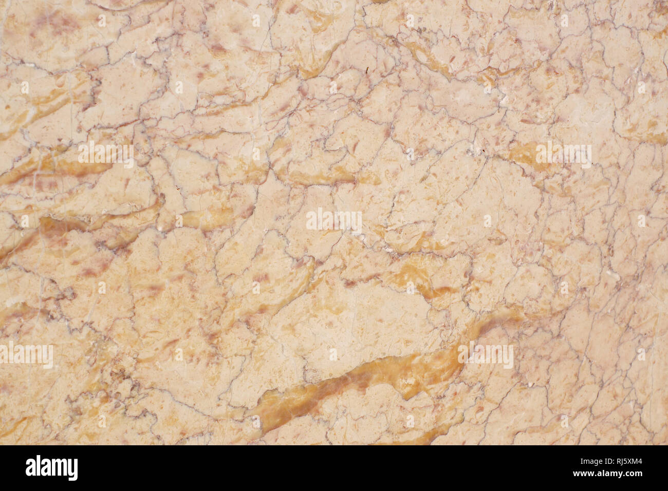 The delicate surface of a yellow natural stone with red stripes is ...