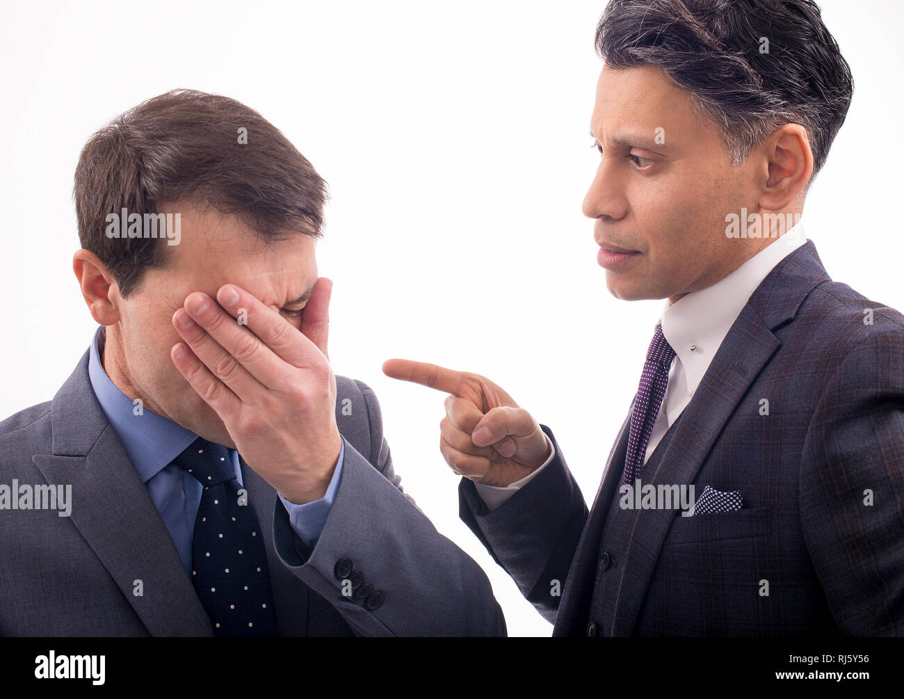 Two businessmen having an argument against a plain white background ...