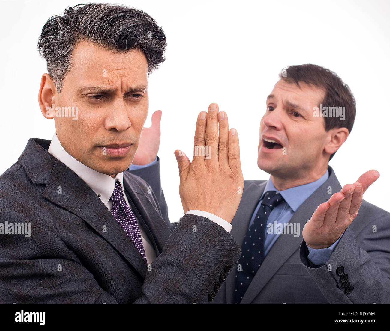 Two businessmen having an argument against a plain white background ...