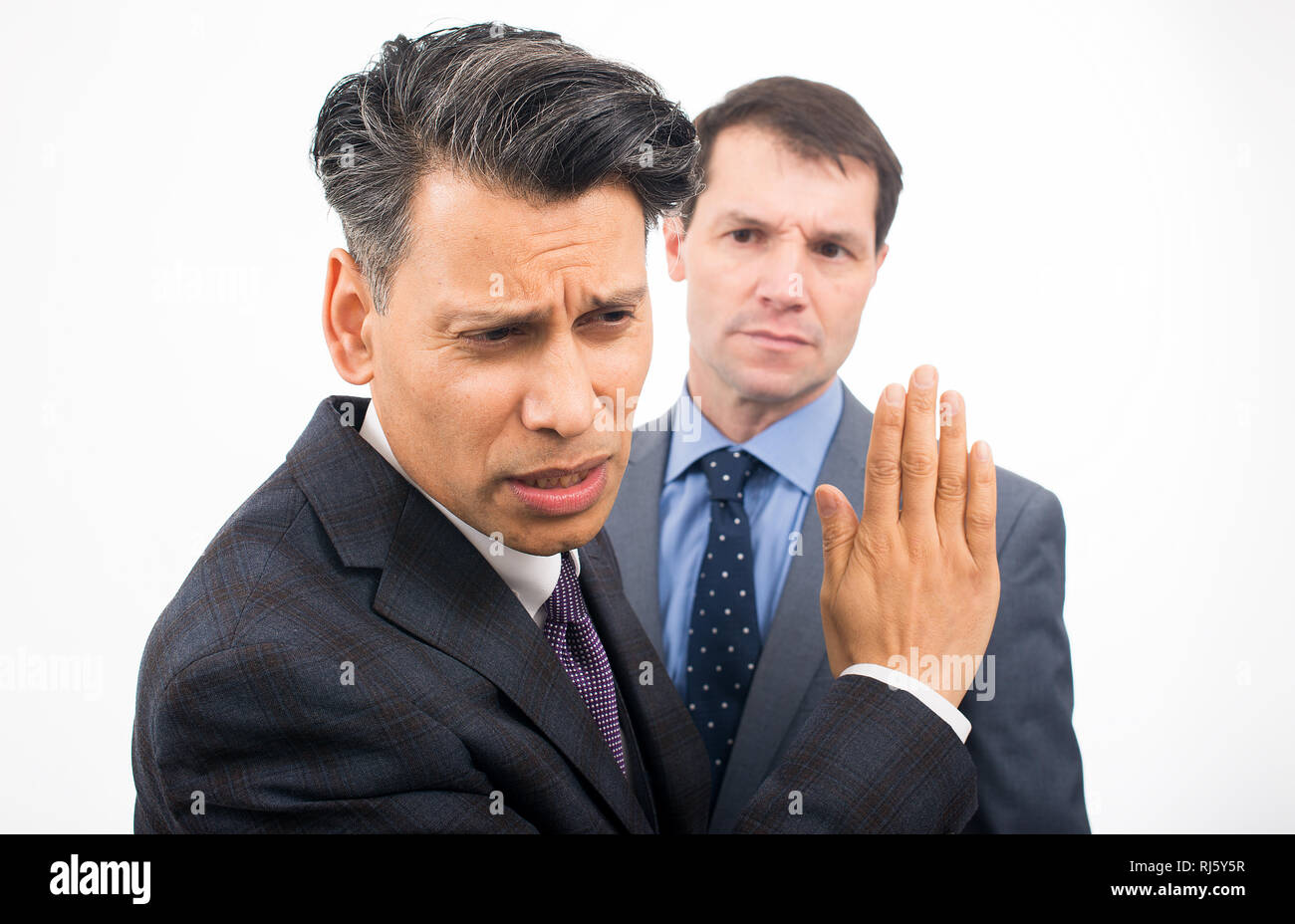 Two businessmen having an argument against a plain white background ...