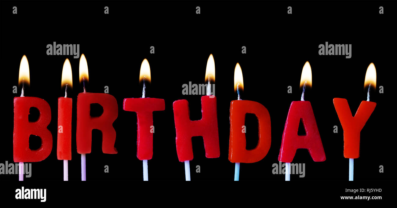 Birthday spellt out in red birthday candles against a black background ...