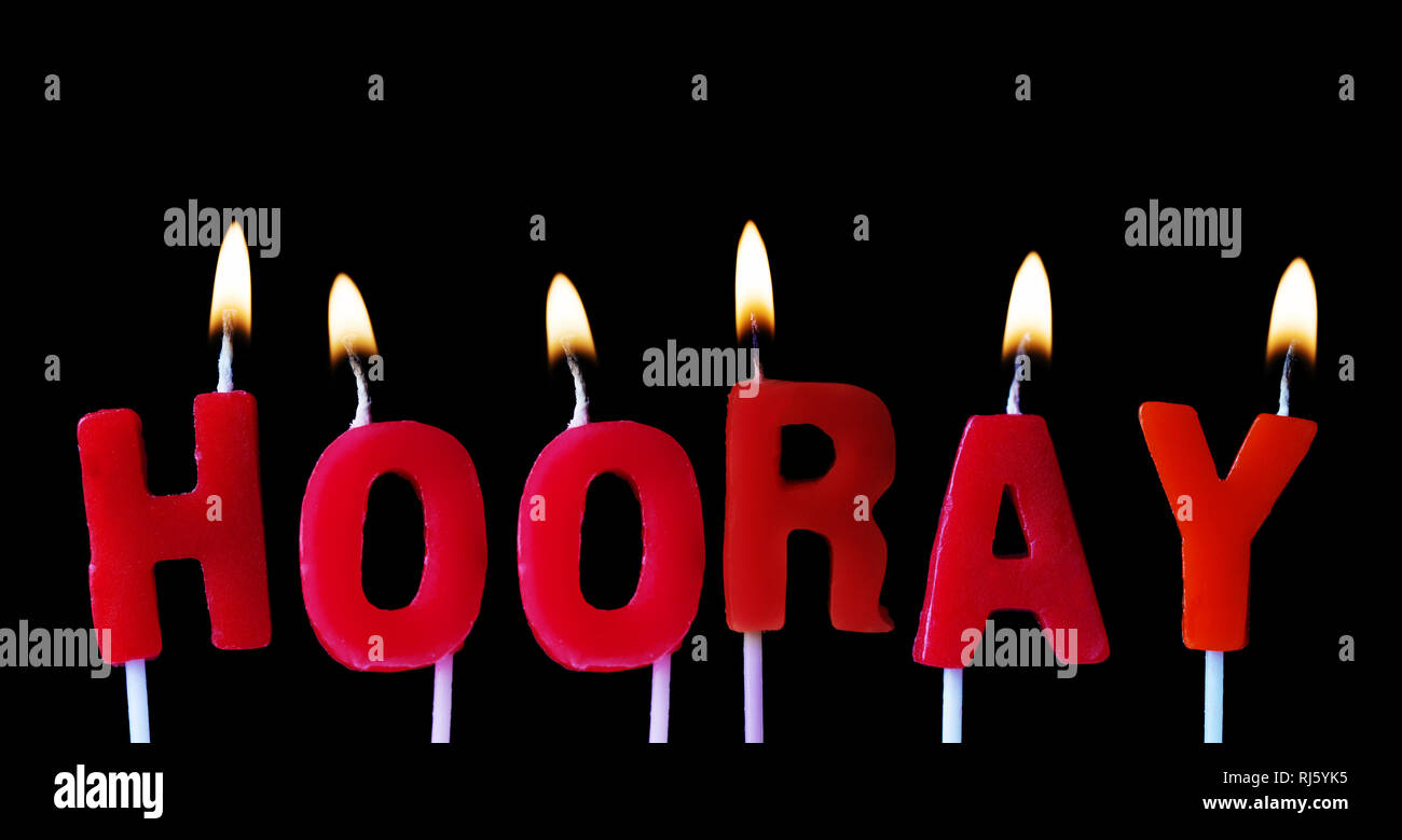 Hooray spellt out in red birthday candles against a black background ...