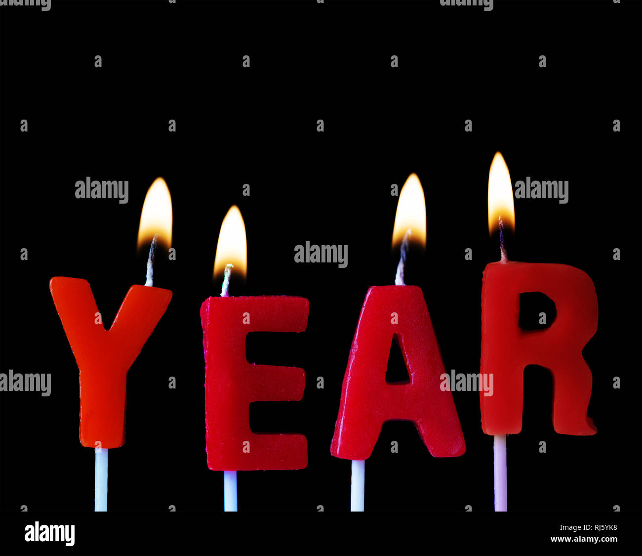 Year spellt out in red birthday candles against a black background ...