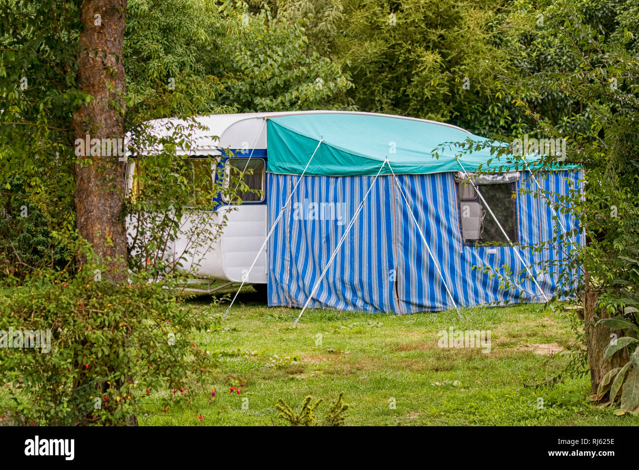 Simple caravan with tent on tranquil spot on camping Stock Photo - Alamy