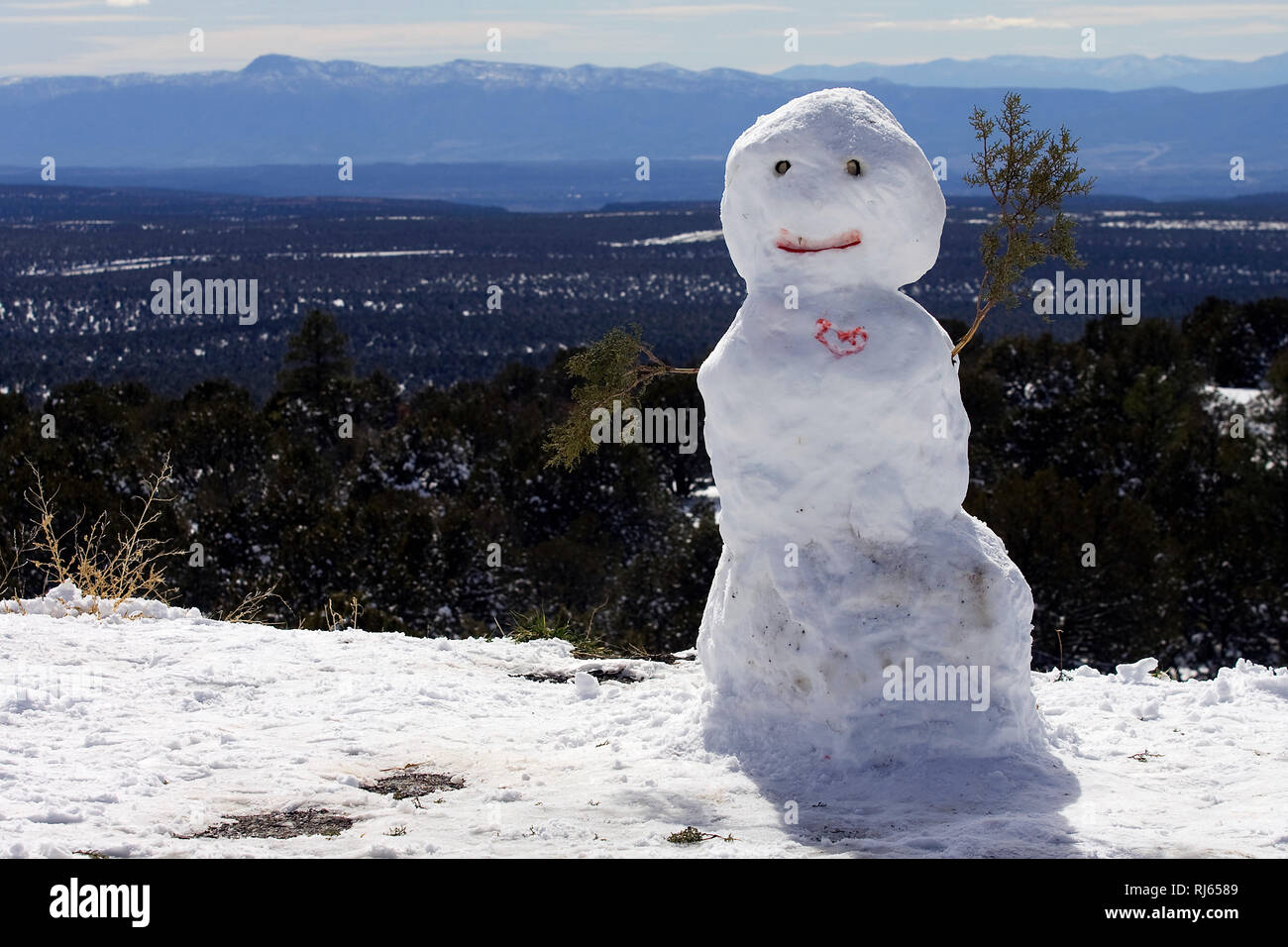 A snowman sits on the edge of a mountain in Flagstaff with the Arizona ...