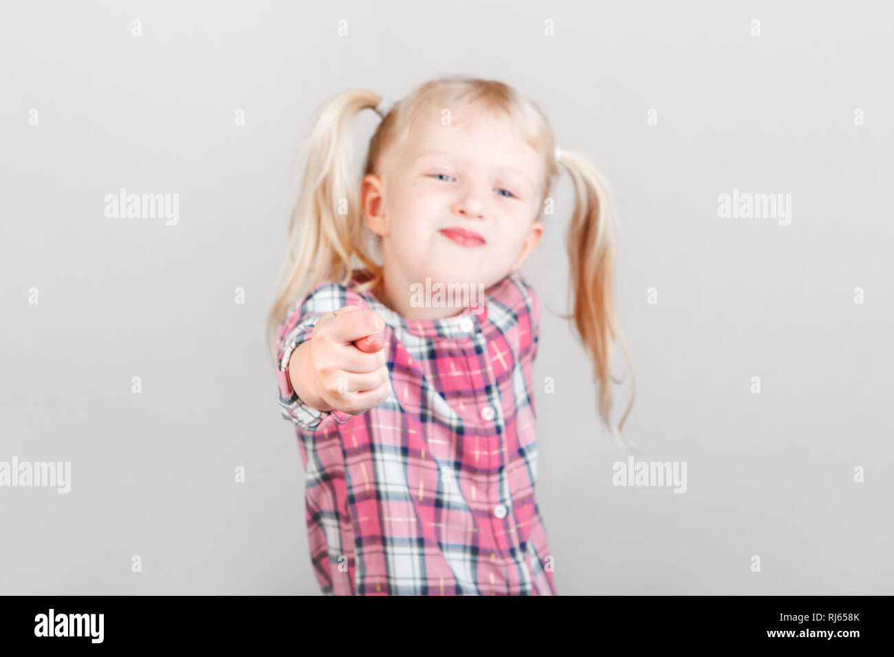 Cute adorable white blonde Caucasian preschool girl making faces in ...