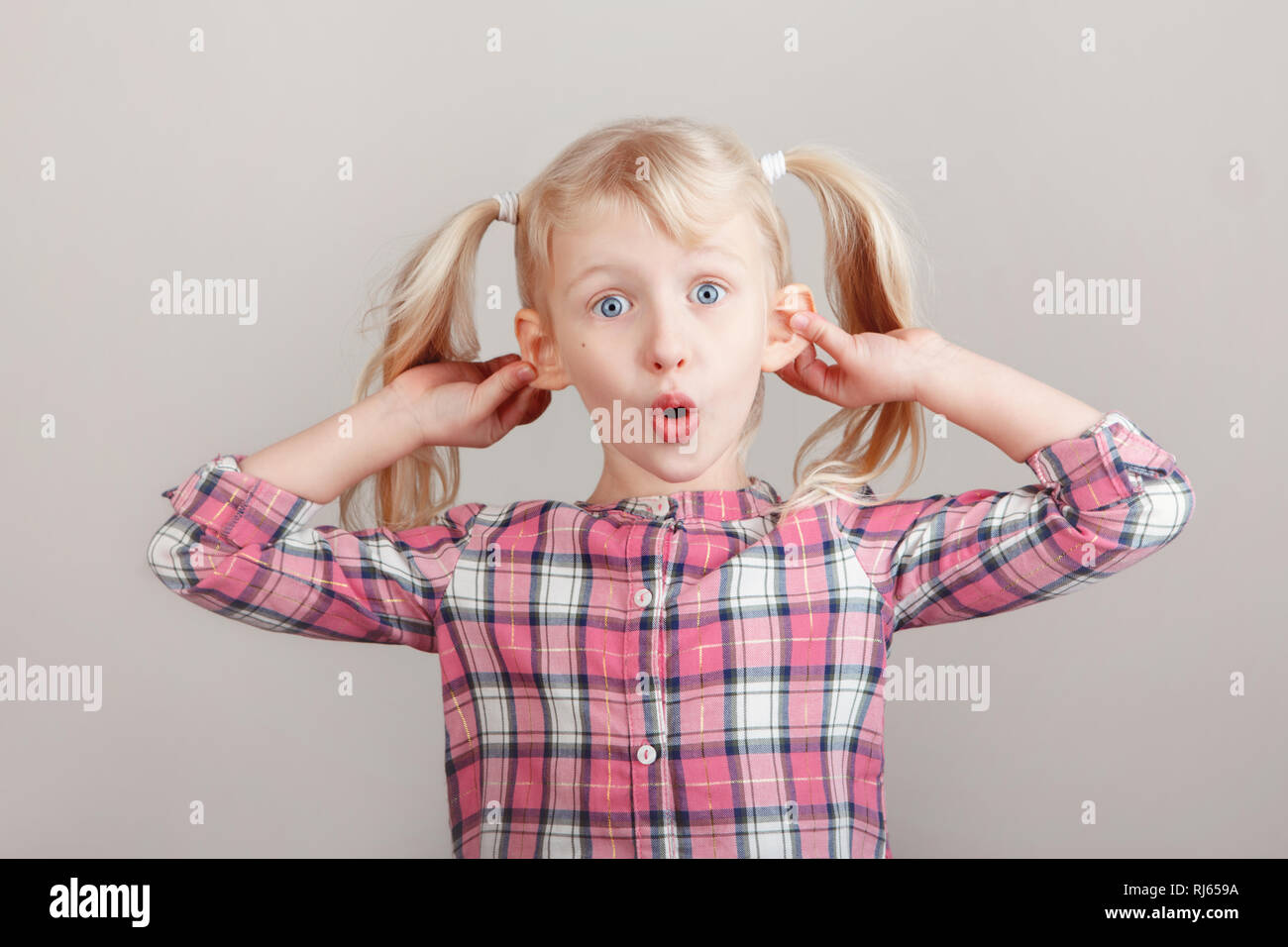 Closeup portrait of funny blonde Caucasian preschool girl making faces ...
