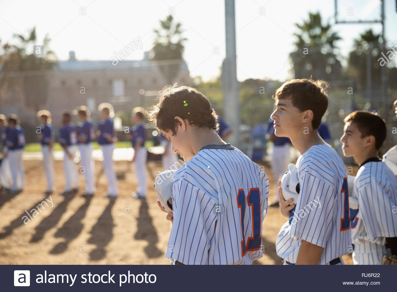 Baseball players standing for national anthem Stock Photo - Alamy