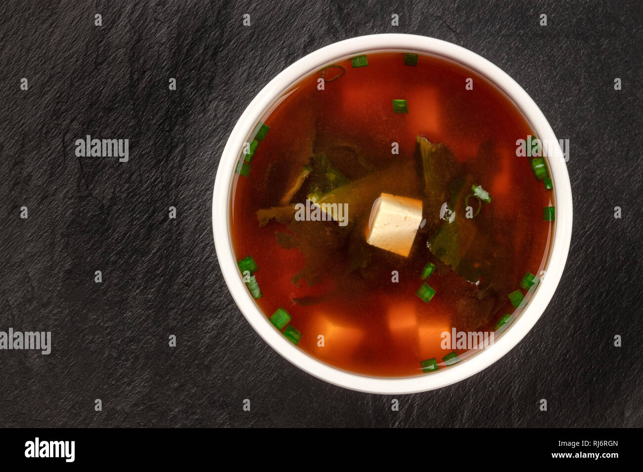 Miso shiru soup with tofu, scallions, and wakame seaweed, shot from the ...