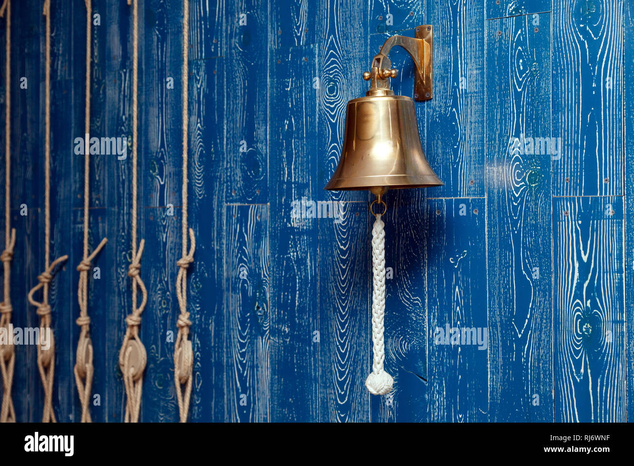 Copper old vintage bell, doorbell, rope on a wooden blue aged wall ...