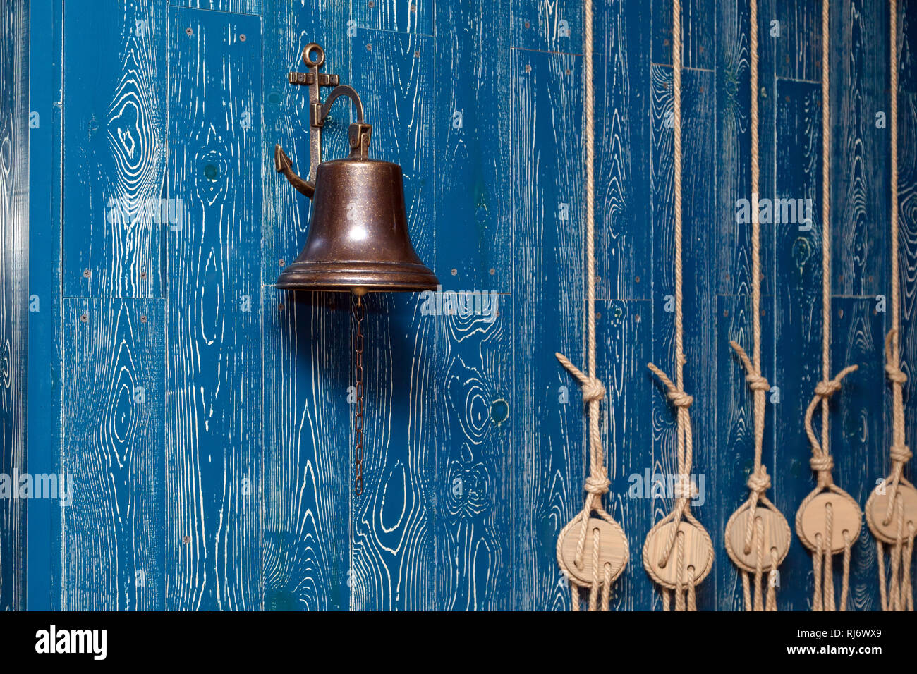 Copper old vintage bell, doorbell, rope on a wooden blue aged wall ...