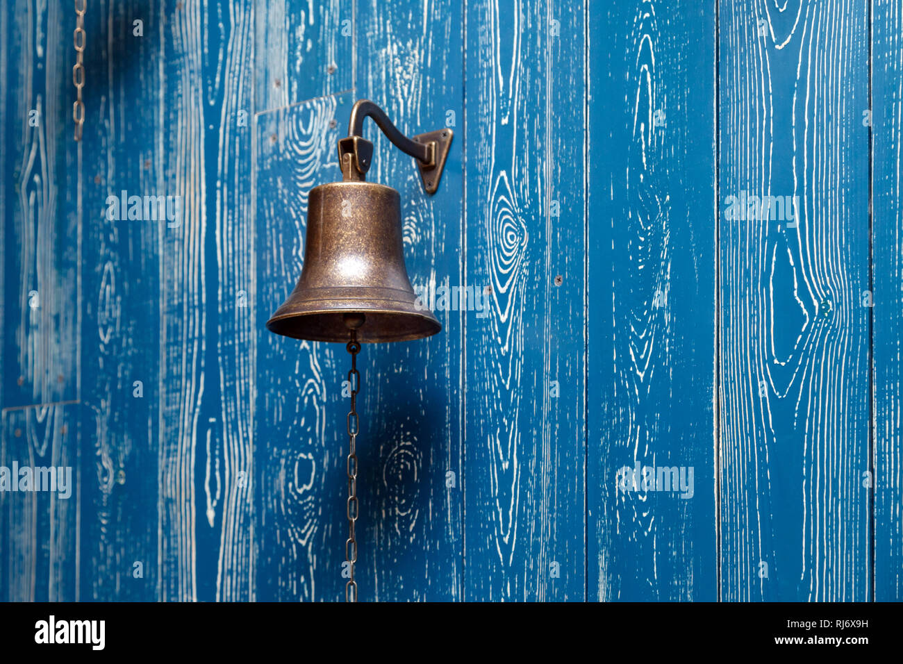 Copper old vintage bell, doorbell, rope on a wooden blue aged wall ...