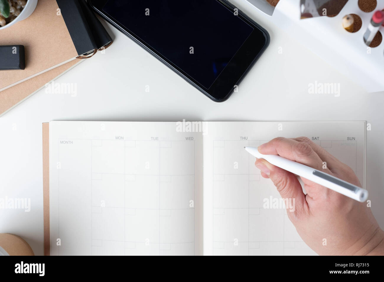 top view of hand writing on open calendar planner for business ...