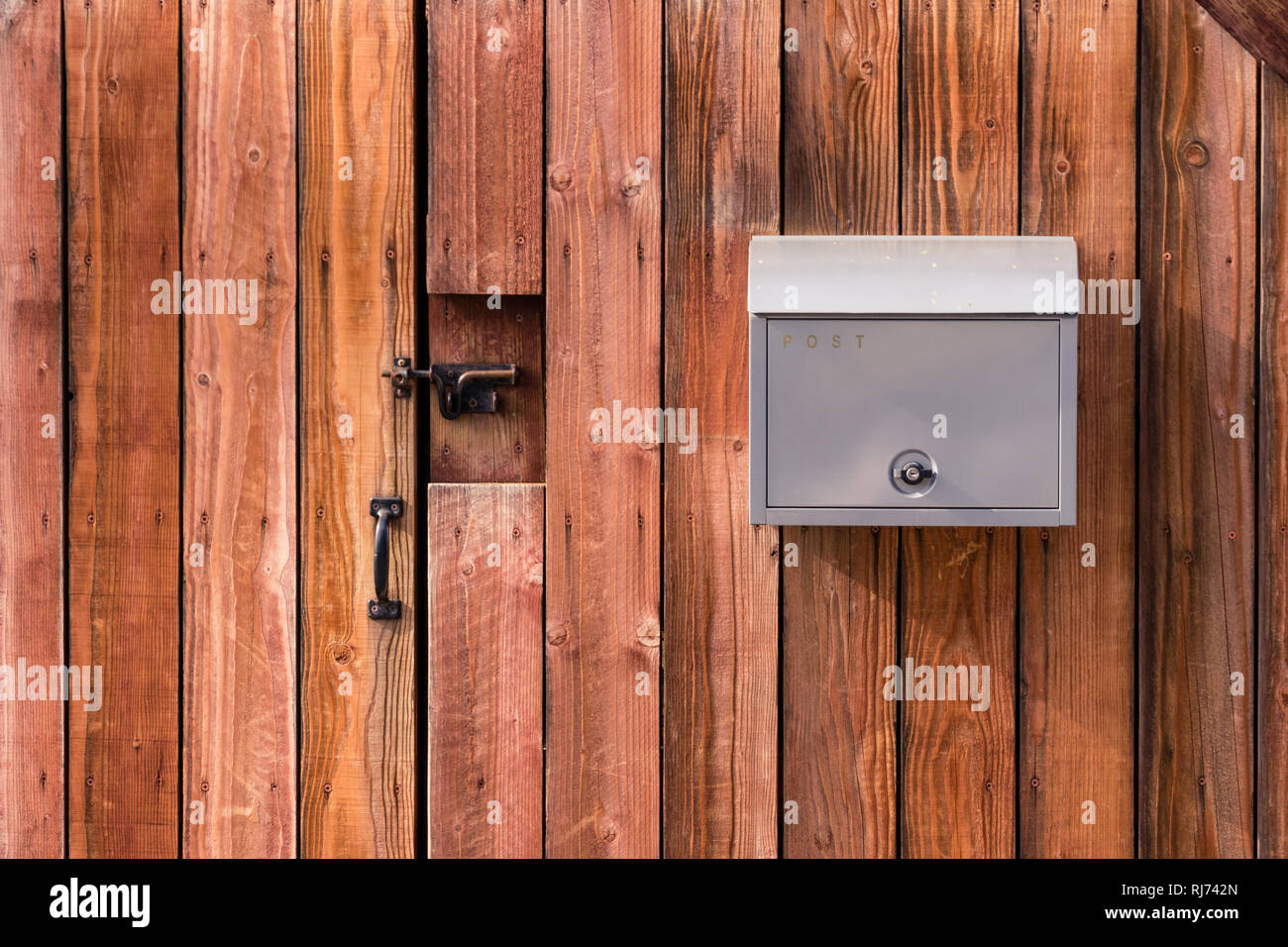 Grey mail box with Post sign on it hanging on new wooden wall, door ...
