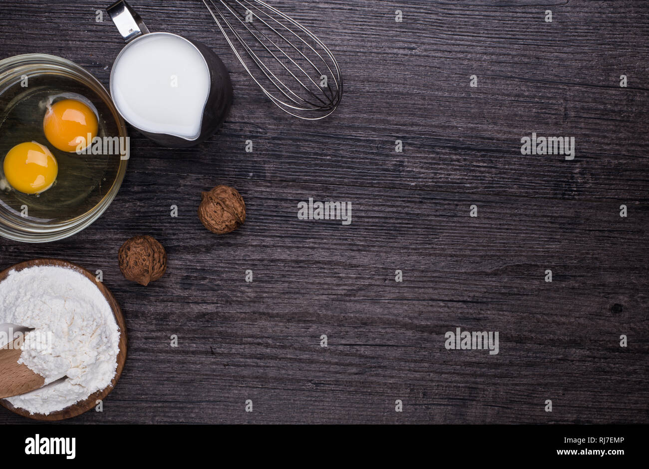 Wooden background with baking ingredients (eggs, flour and rolling pin ...
