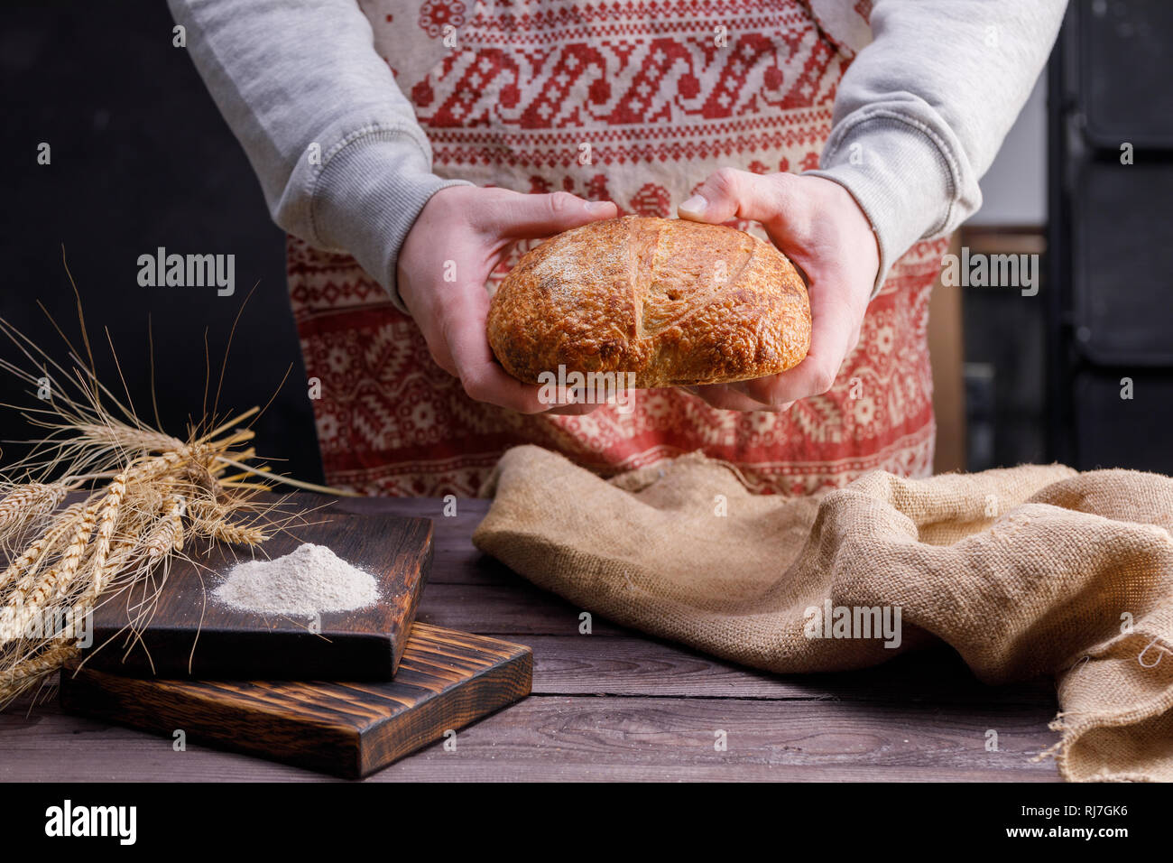 Round artisan bread in the hands of a baker. The concept of healthy ...