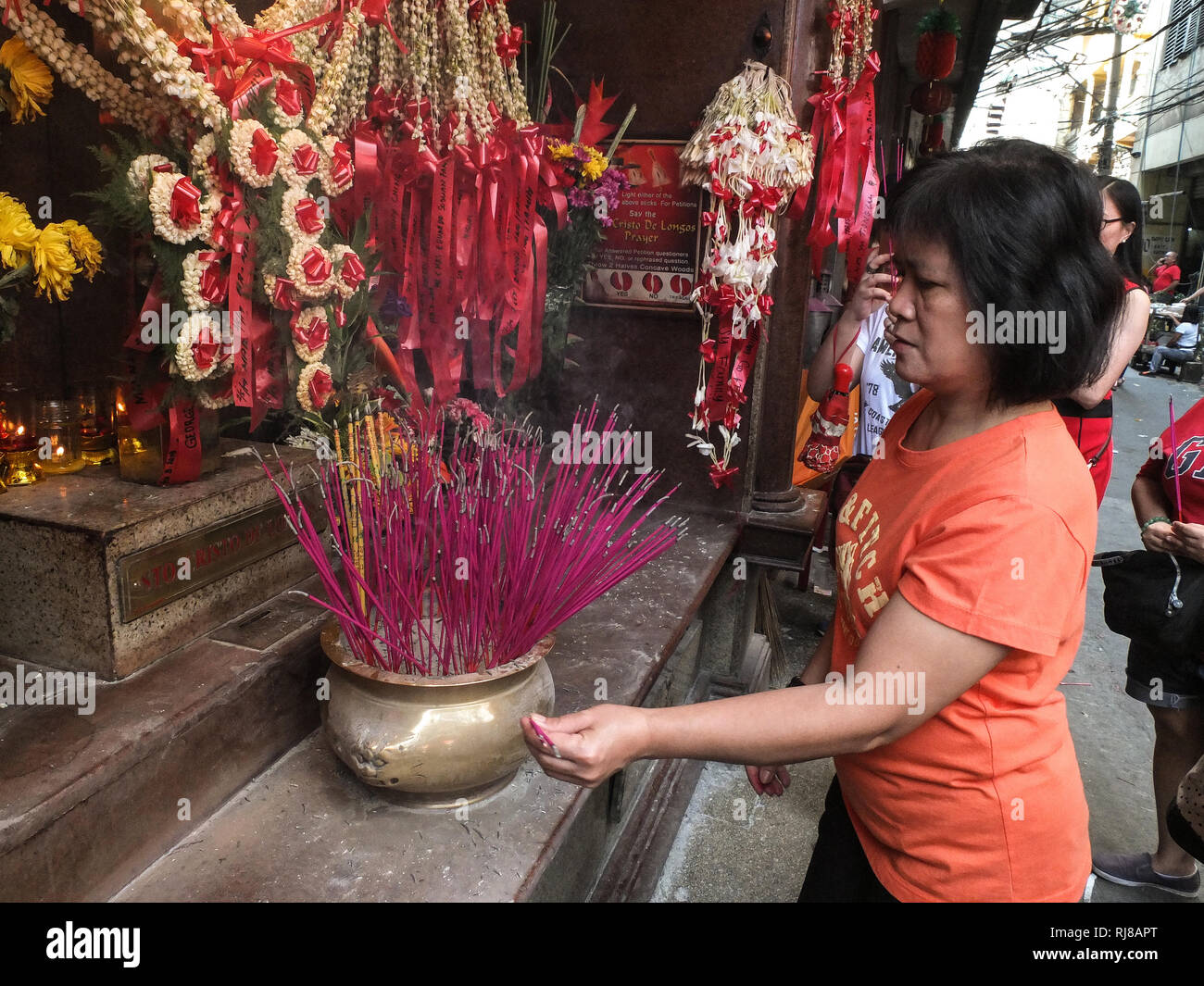 A Filipina-Chinese woman, light an incense in an altar in Binondo ...