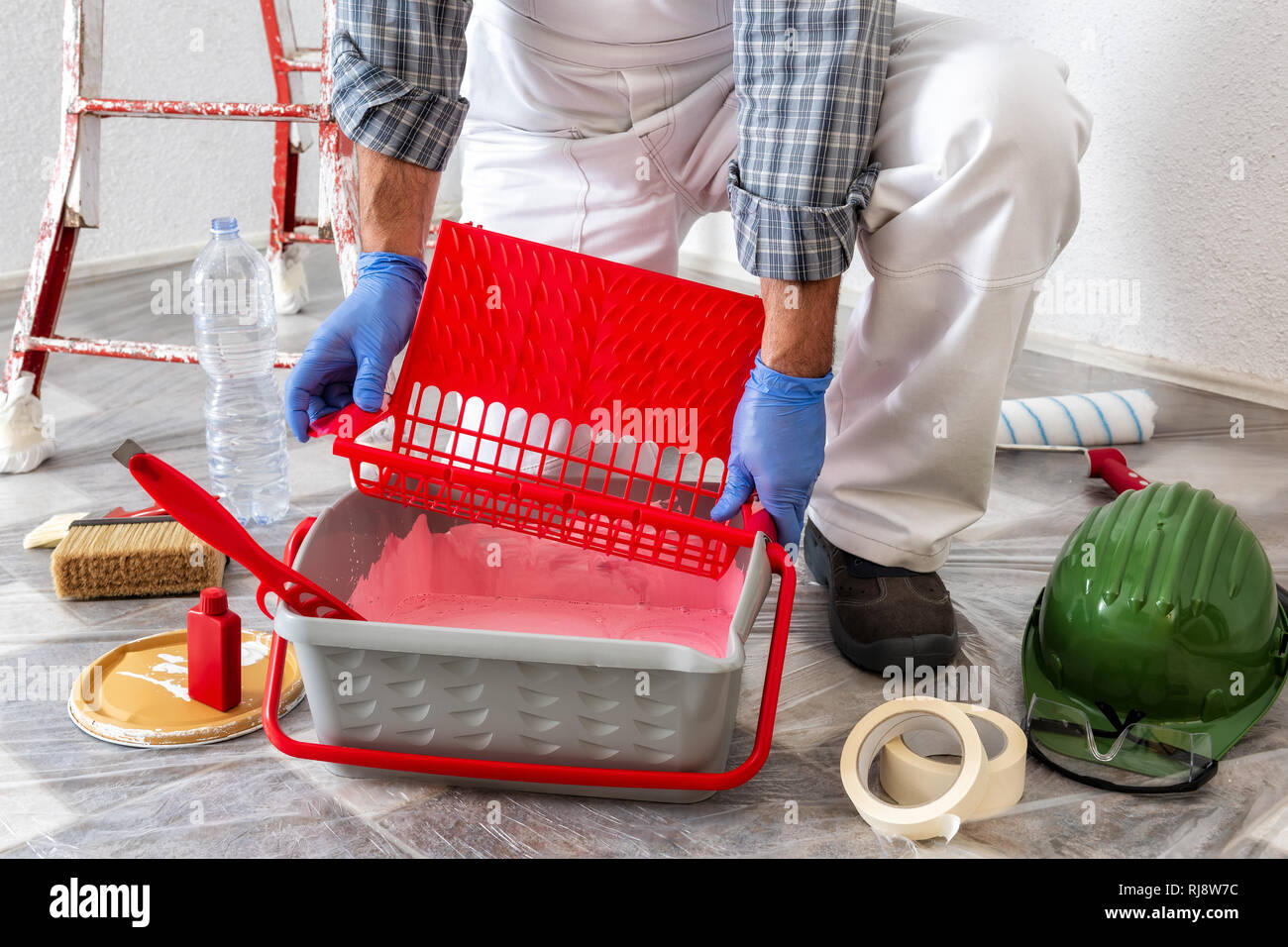 Caucasian worker house painter at work, preparing the paint for ...