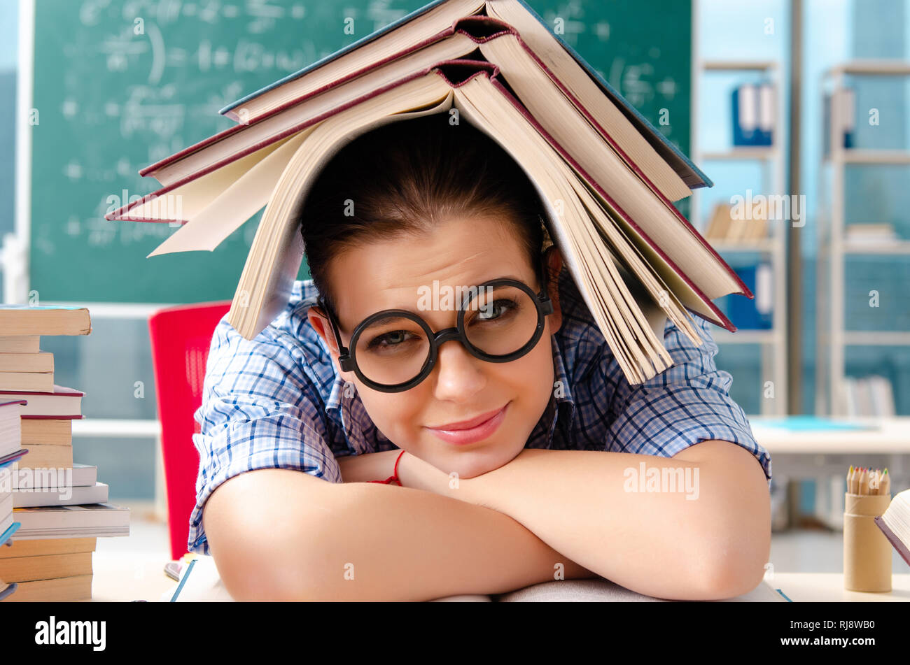 Female student with many books sitting in the classroom Stock Photo - Alamy