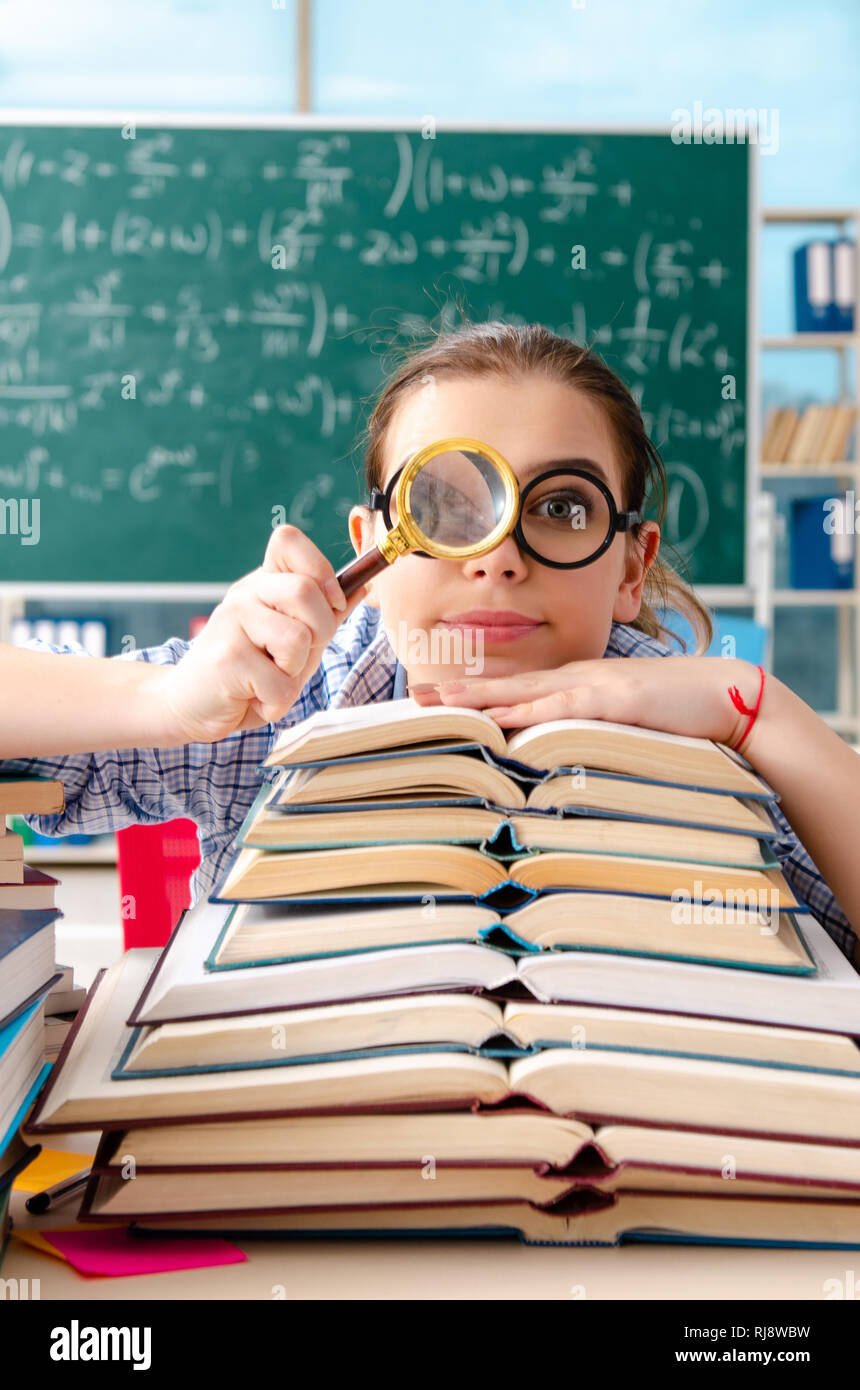 Female student with many books sitting in the classroom Stock Photo - Alamy